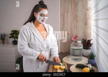 Young woman drinking cucumber water on blue background Stock Photo - Alamy