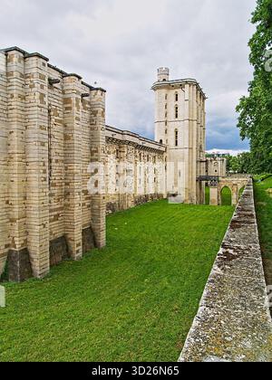A historic stone fortress stands against a vibrant blue sky, framed by ...