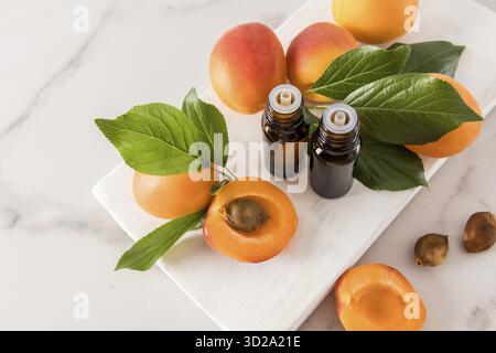 Bottles of apricot essential oil on color background with space for ...