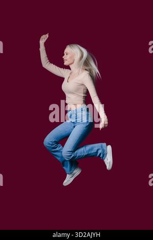 Blonde woman in denim attire smiling while listening music in retro ...