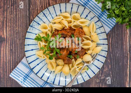 Creamy beef Diane stew with pasta shells Stock Photo - Alamy