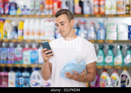 Man examines product liquid detergent in store Stock Photo - Alamy