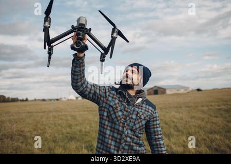 Man pilot holding quadcopter drone in hands at outside field Stock ...