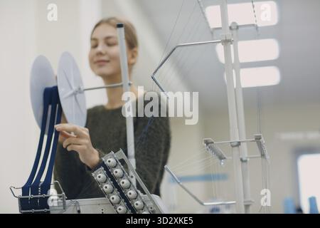 Young beautiful seamstress sews on sewing machine in factory Stock Photo - Alamy