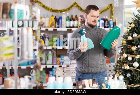 Middle-aged man choosing detergent in big supermarket Stock Photo - Alamy