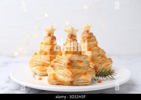 Christmas trees made with puff pastry, red caviar and fir branches on ...