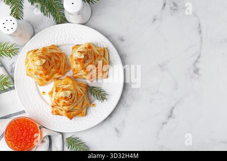 Christmas trees made with puff pastry and red caviar on white ...