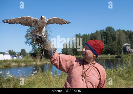 A man holds a falcon on hand in winter Stock Photo - Alamy