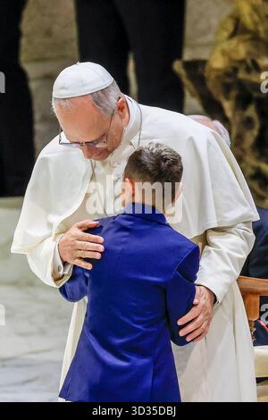 Pope Leo XIV greets a child as he arrives for his weekly general ...