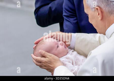 Pope Leo XIV caresses a baby as he arrives at the Pavia's Cathedral ...