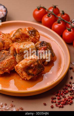 Pieces of fried hake fish in a plate with pepper on a wooden table ...