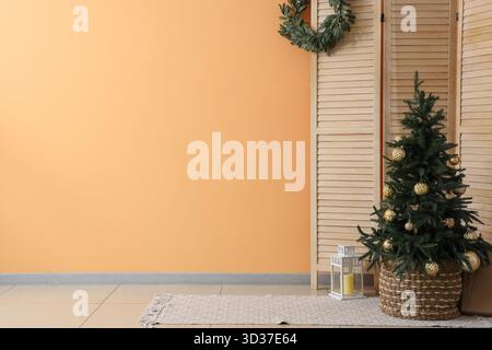 Folding screen and Christmas wreath near color wall, closeup Stock ...