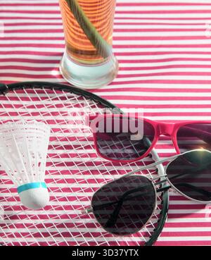 A top view of a sun hat with a pair of sunglasses on it on a yellow ...
