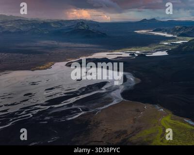 Braided glacial rivers wind across dark volcanic plains near ...