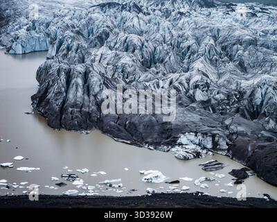 Aerial view of crevassed glacier tongue and proglacial lake in Iceland ...