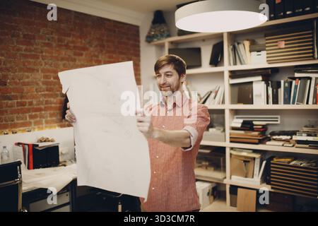 Architect with blueprints and layout design project at office bureau ...