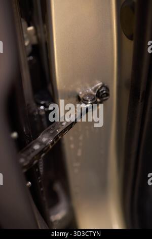 Applying spray lubricant to car door hinges helps keep them functioning ...