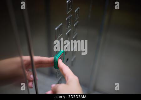 A video displaying a closeup view of someone pushing elevator buttons ...