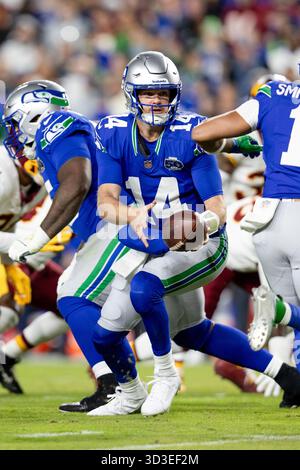 Seattle Seahawks quarterback Sam Darnold (14) rolls out of the pocket ...