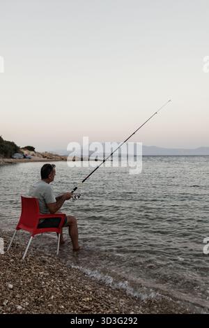 A serene beach scene at dusk with the sun setting over the ocean ...