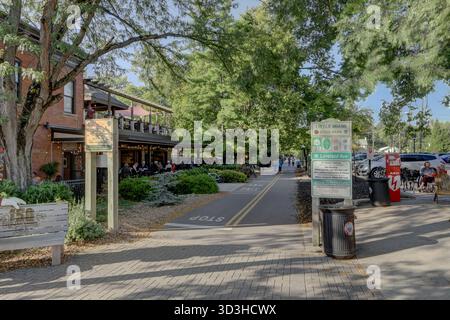 View of brick building with pavement beside bush with autumn leafs ...