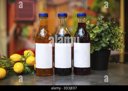 Three glass bottles containing liquids, one glass dropper, green leaves ...