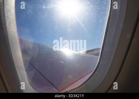 Sunlight on airplane wing seen through window during Wizz Air flight on ...