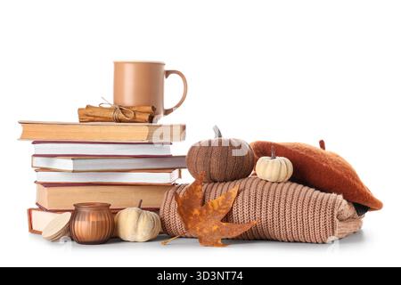 Stack of different books, knitted sweater and autumn decor on white ...