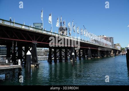Pyrmont Bridge, a historic swing bridge, extends across Darling Harbour ...