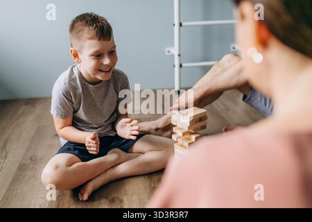 Father and child bonding while building a tower with toy blocks on the ...