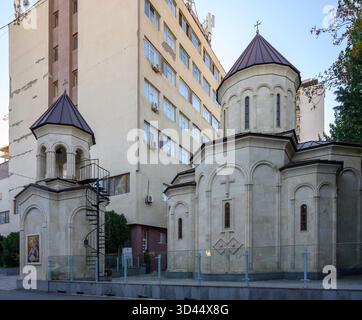 A stone cross stands beside a small chapel within the sanctuary grounds ...