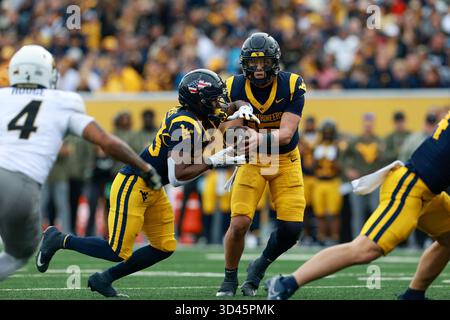 West Virginia running back Cyncir Bowers, left, runs with the ball ...