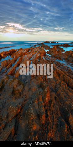 Twilight ocean coast with ribbed stratiform rock formations. (Atlantic ...