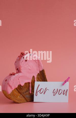 Heart shaped strawberry berry croissant on pink background with copy ...