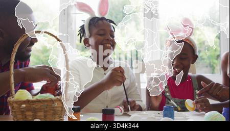 Boy in a plaid shirt is decorating the cookies in the shape of an angel ...