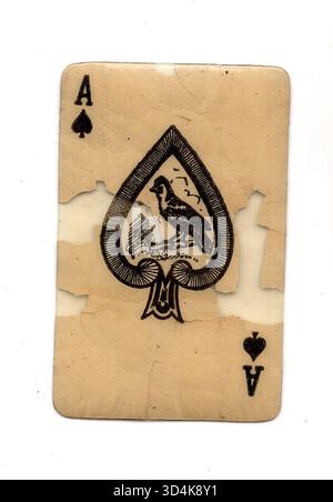 A badly damaged vintage playing card in the suit of spades isolated on ...