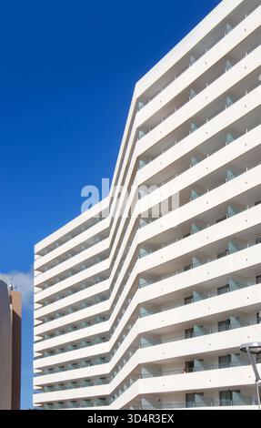 Modern apartment building facade with white walls, large windows and ...