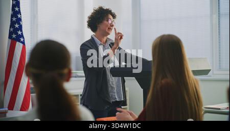 American Teacher Stands Podium Beside US Flag, Engaging Students In ...