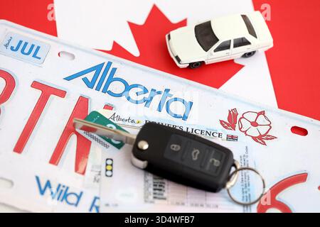 Alberta canadian car license plate on flag of Canada close up. Driving ...