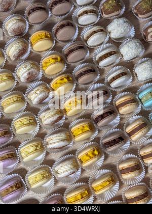 French macarons on the wooden miniature table near bench in cafe style ...