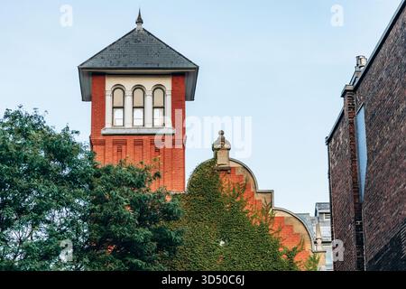 Historic red brick fire station tower and ivy wall of Centre d’histoire ...