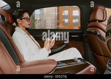 Woman using smartphone inside a car Stock Photo - Alamy