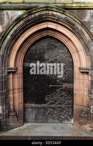 A weathered wooden door with ornate metalwork and peeling paint ...