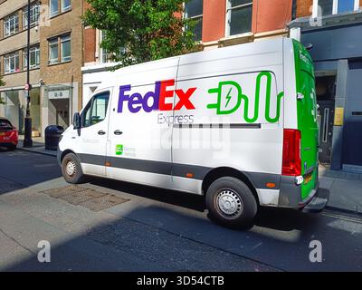 FedEx electric delivery van with sustainability branding parked on city ...