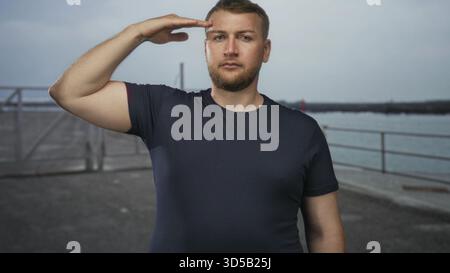 Man salutes with right hand to forehead on city street, wearing red ...