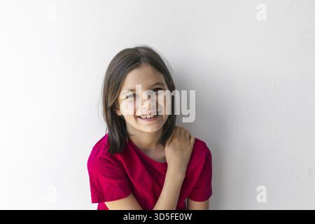 Happy childhood concept. Girl smile in shirt and pants on orange ...