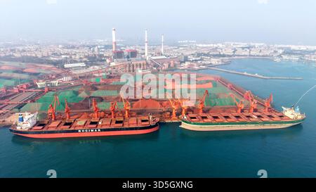 A cargo ship unloads imported iron ore at the Qingdao Port Ore Terminal ...