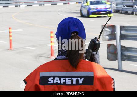 Professional safety marshal in an orange vest attentively watching race ...