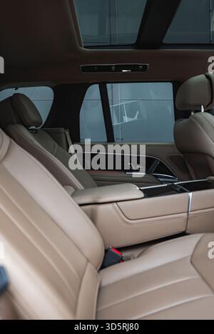 Rear cabin of luxury SUV with tan leather and glossy console Stock ...