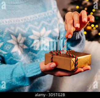 Woman in blue sweater with gift box for Valentine's Day on grey ...